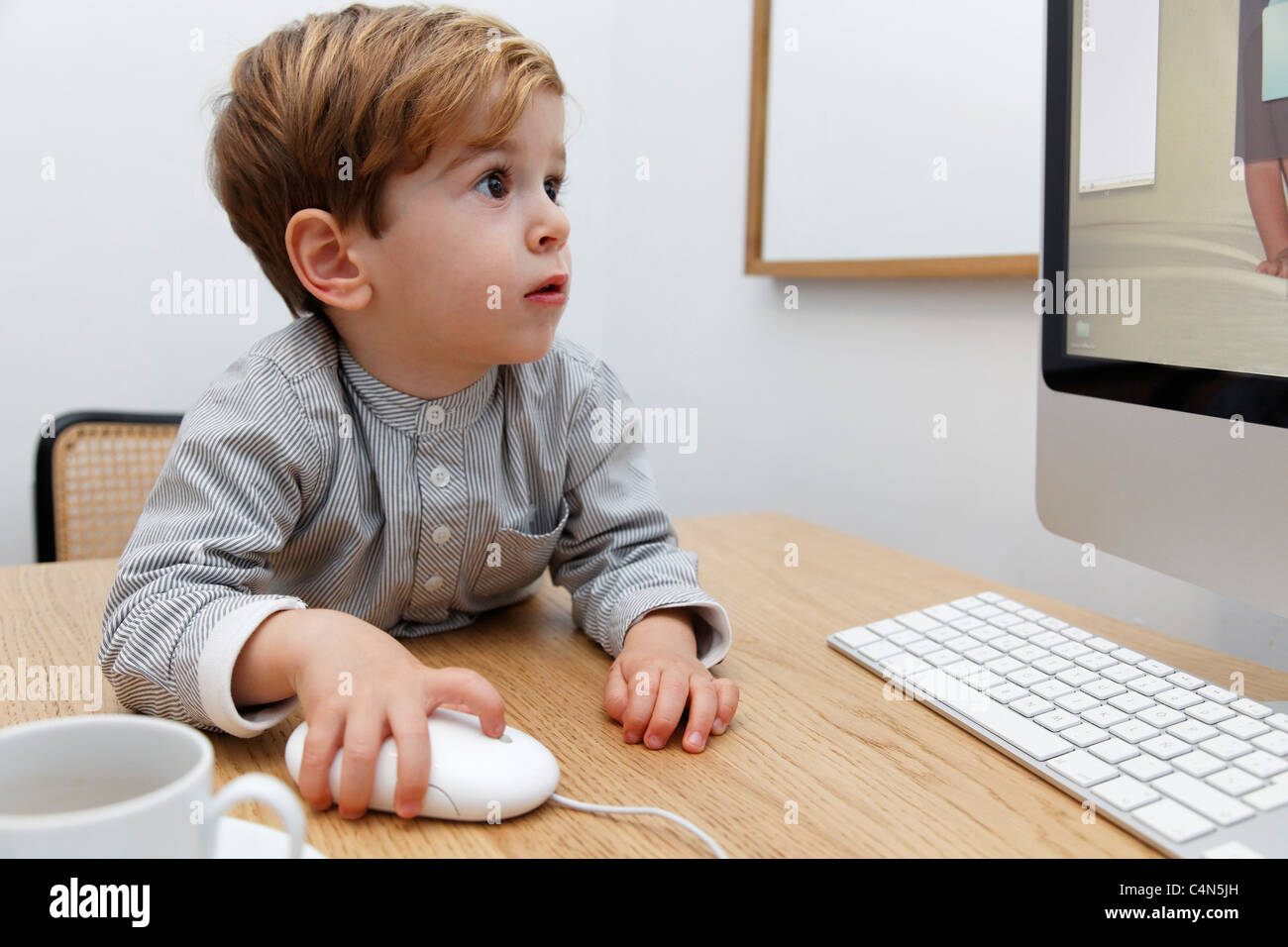 Young boy exploring a computer, using a mouse Stock Photo - Alamy