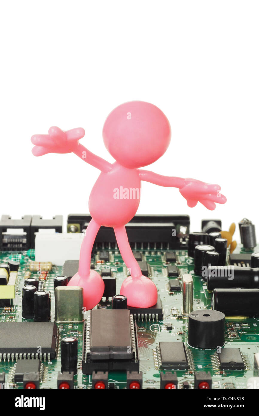 Rubber figurine playing on electronic circuit board with copy space ...