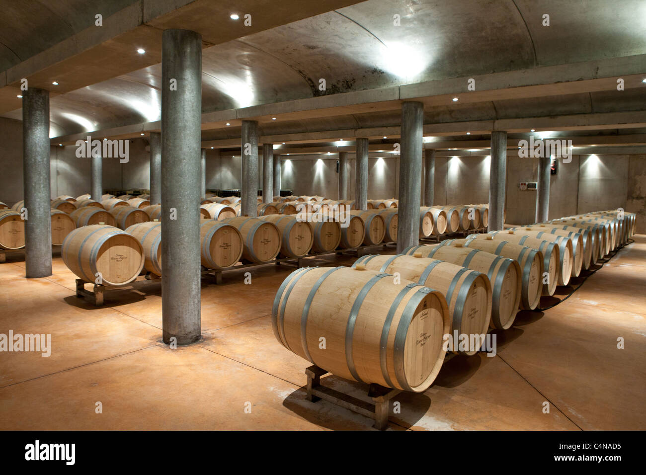 Oak wine barrels in cave at Chateau Beau-Sejour Becot at St Emilion in ...