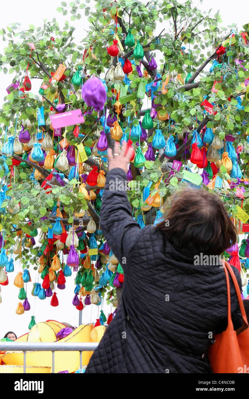 lady throwing a fortune bag into a wishing tree at the Dragon boat ...