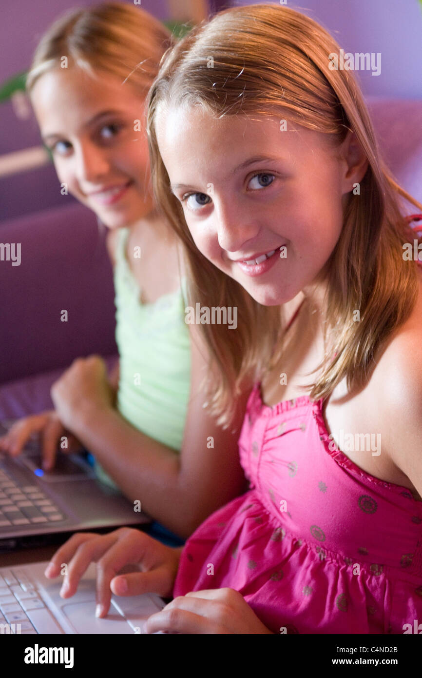 Two girls side by side on laptops Stock Photo - Alamy