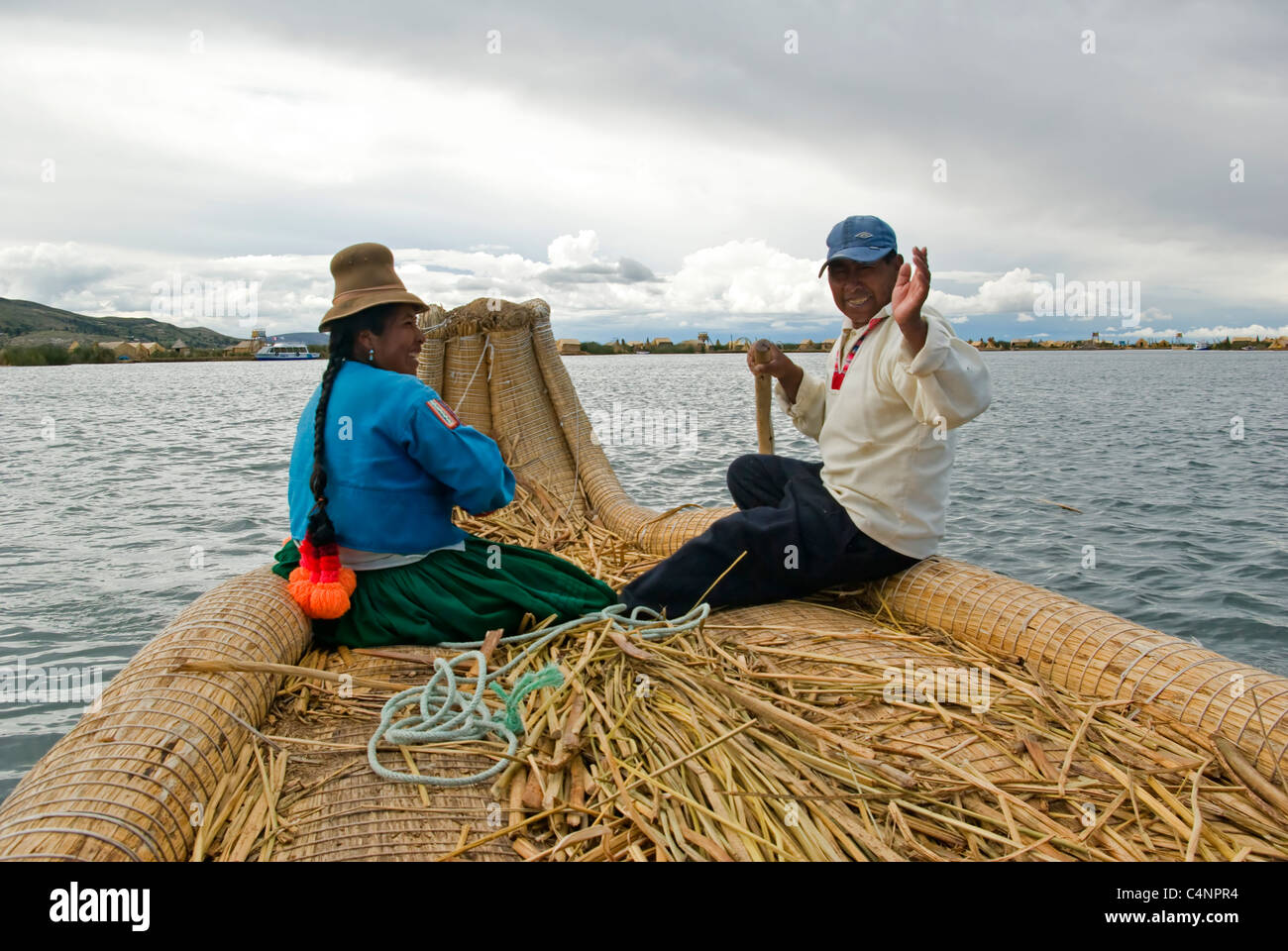 Man and woman row traditional reed boat on Lake Titicaca, Isla ...