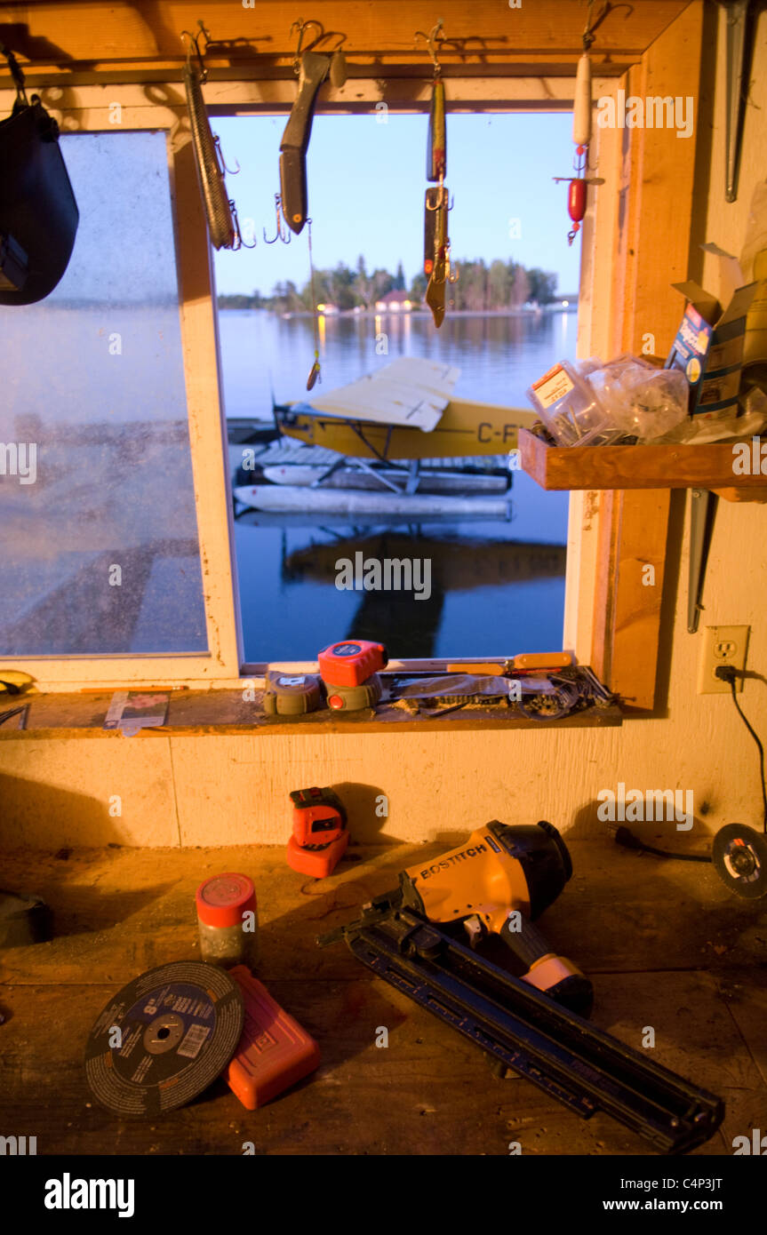 View through the window of a tool shed looking at a Piper Cub float ...