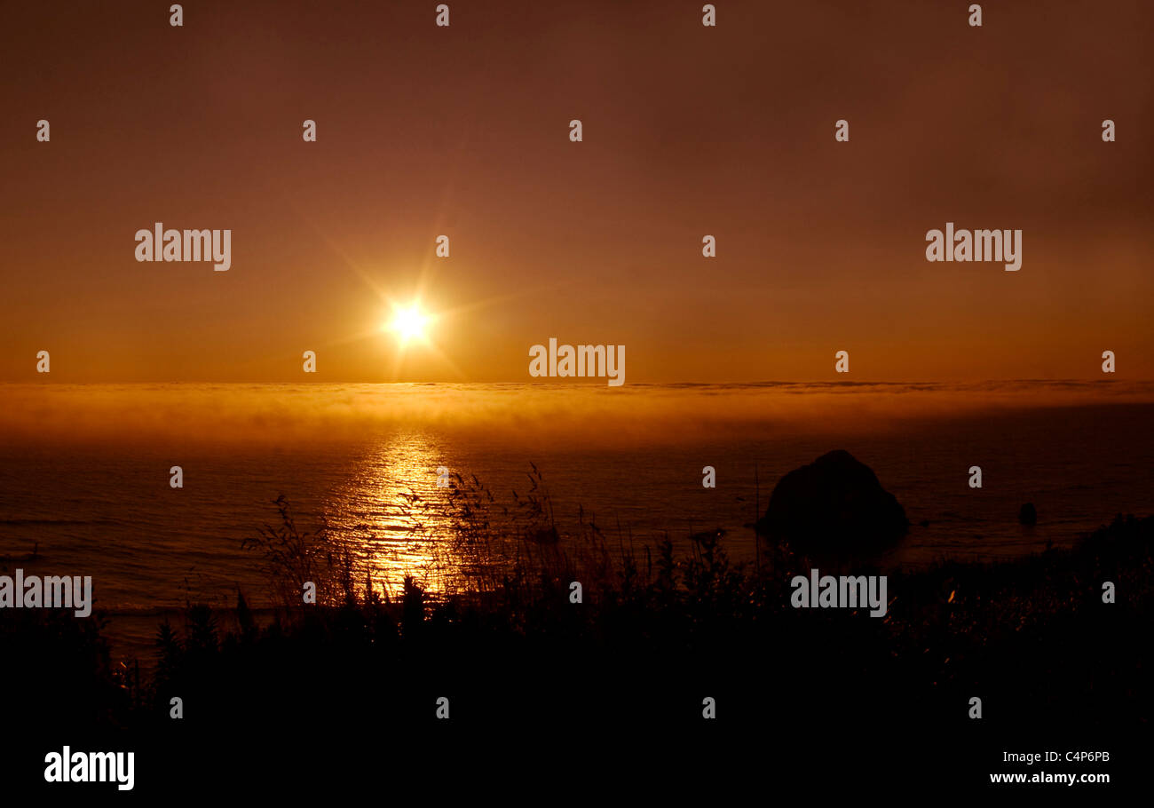 Heavy fog rolling over Pacific Ocean at dusk near Cannon Beach, Oregon ...