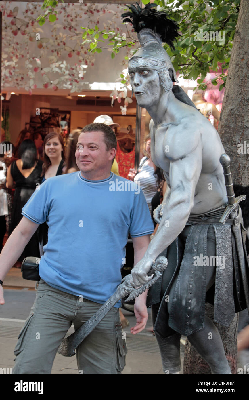 A street entertainer, dressed as a scary Roman Centurion, plays with a ...
