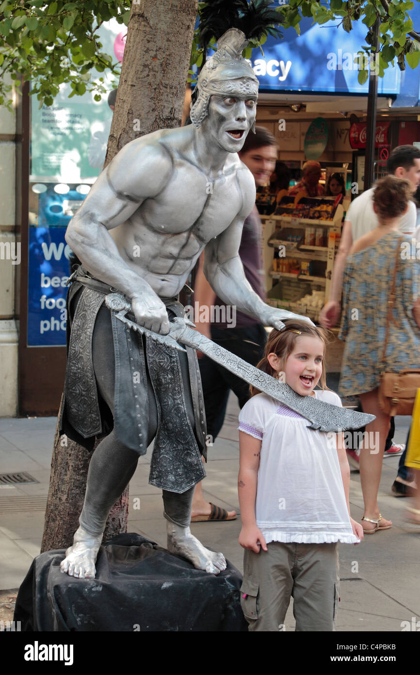 A street entertainer, dressed as a scary Roman Centurion, ''cutting ...