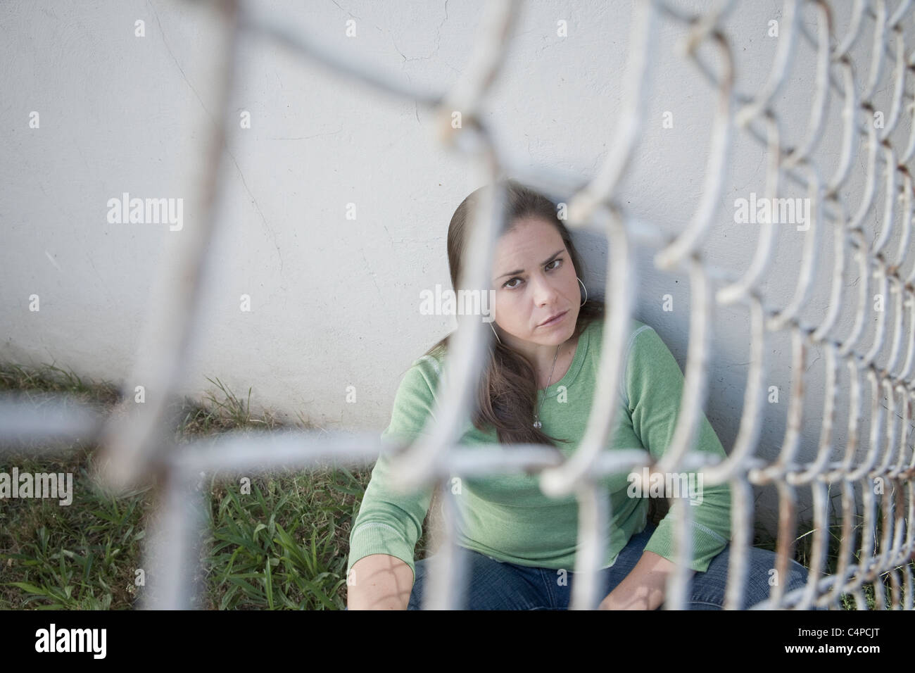 Young woman behind a chain-link fence Stock Photo - Alamy