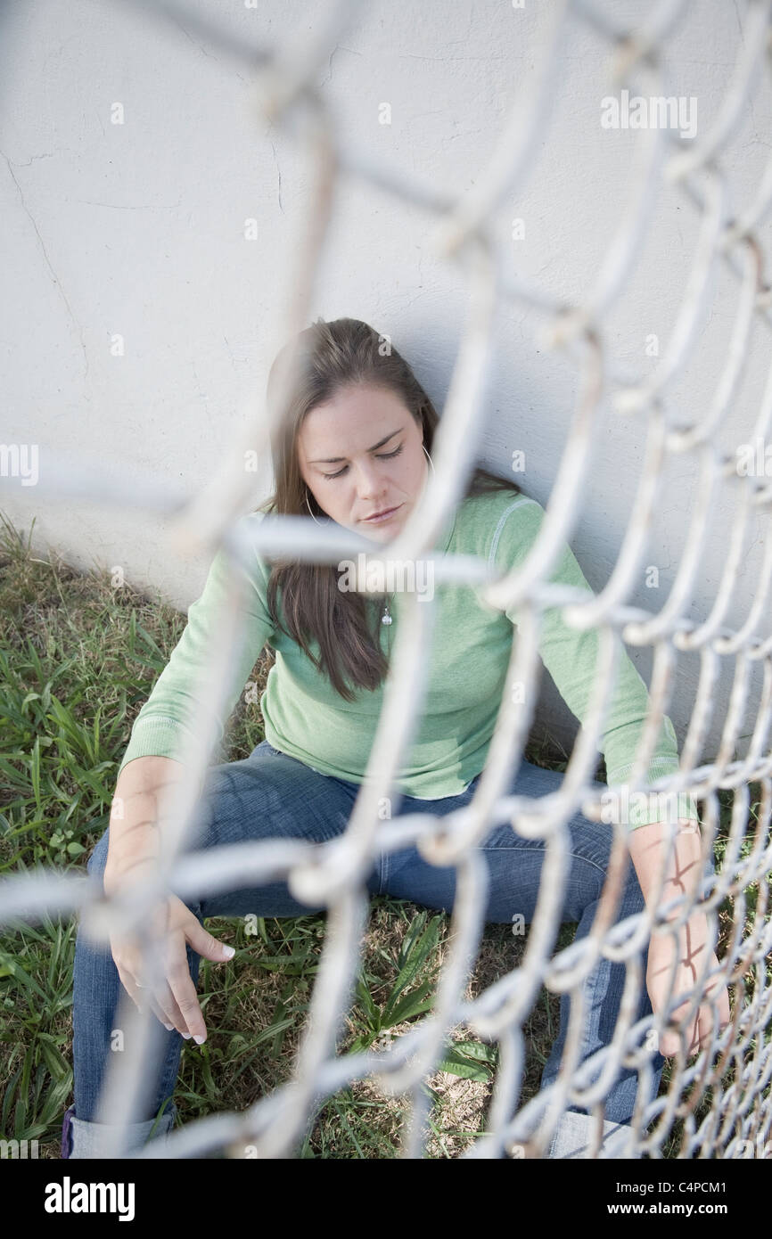 Young woman behind a chain-link fence Stock Photo - Alamy