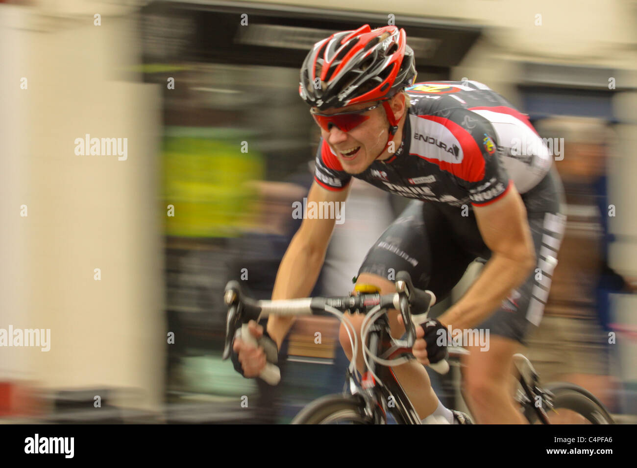 Man cycling in town centre road race Stock Photo - Alamy
