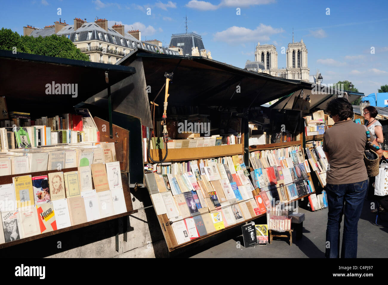 People browsing the books at a booksellers by the river Seine in Paris ...