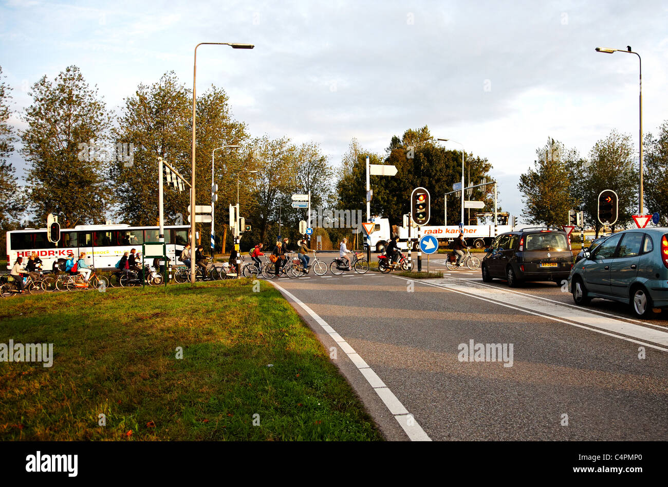 Cyclist crossing a traffic light on their ways to work and to school ...