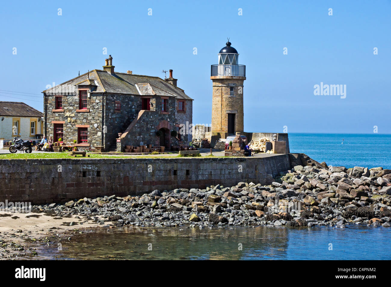 The old lighthouse at the entrance to Portpatrick harbour in Dumfries ...