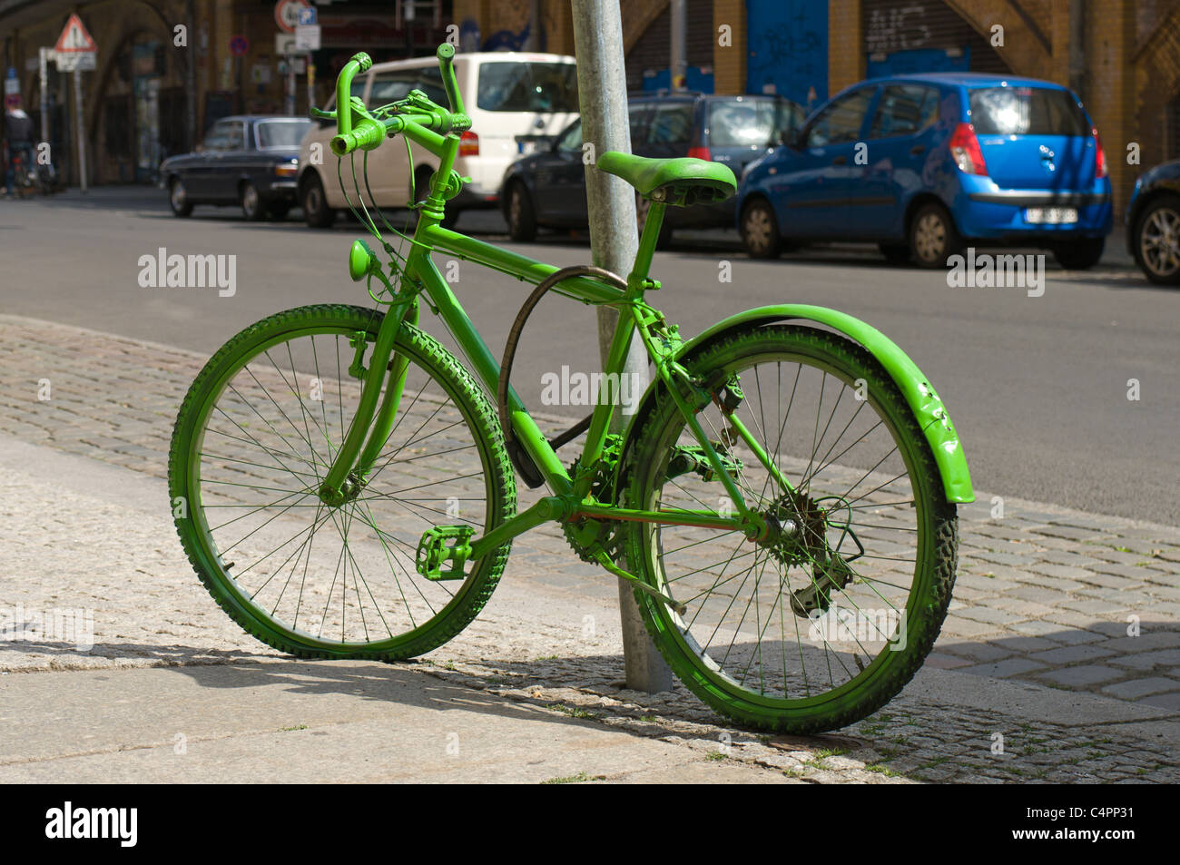 Old green bicycle chained to a pole Stock Photo - Alamy
