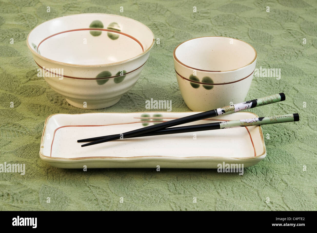 A contemporary Japanese place setting including a rectangular plate ...