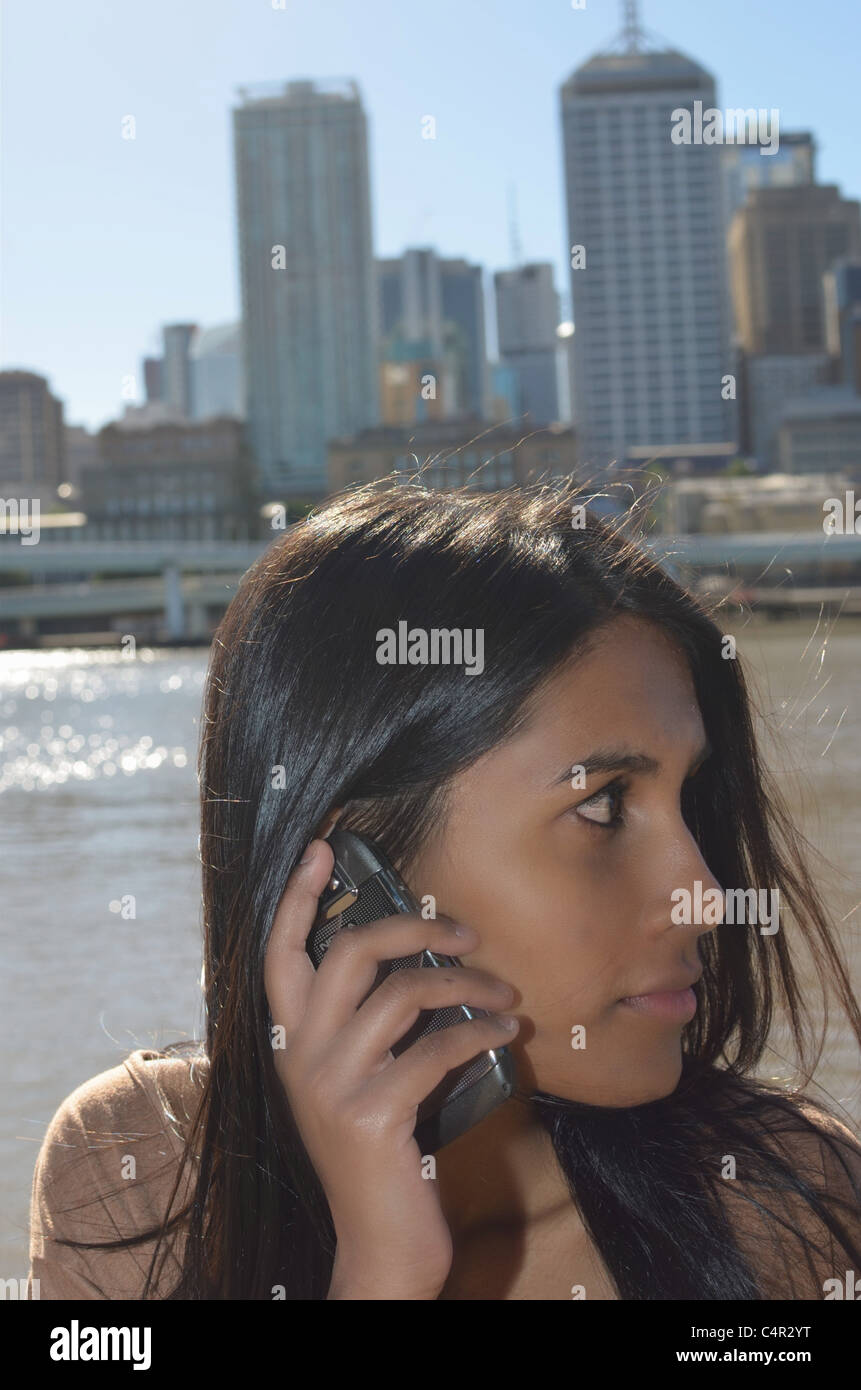 City Call. A young lady making a call on her mobile phone at South Bank ...