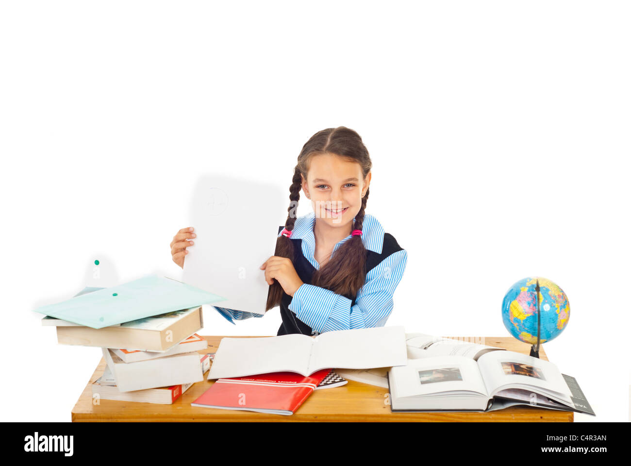 Happy schoolgirl showing white paper with A+ and sitting at pupil with ...