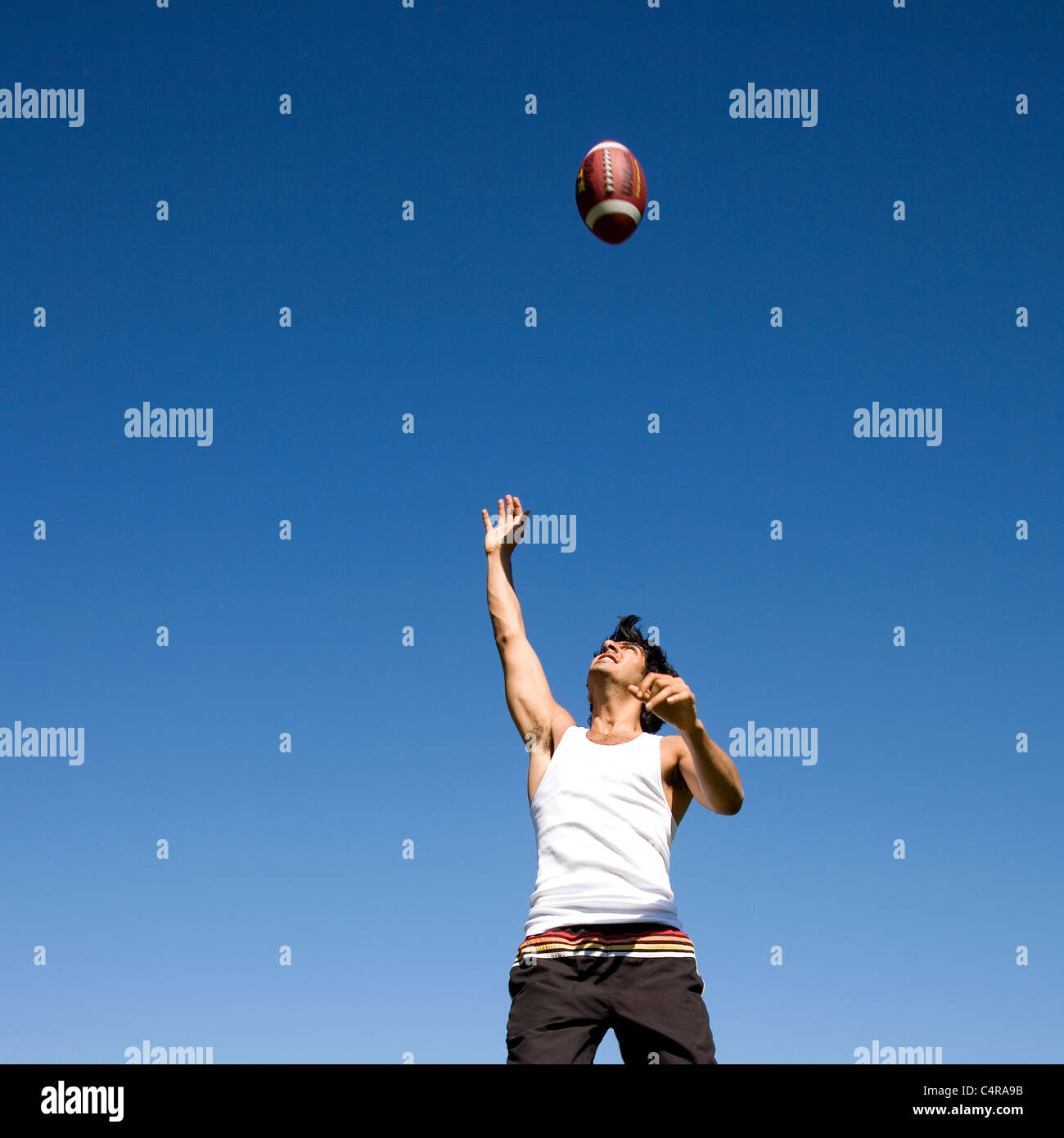Young guy reaching for ball Stock Photo - Alamy
