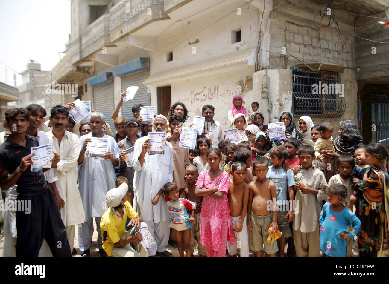 Residents of Lasi Para area at Malir area hold their paid electricity ...