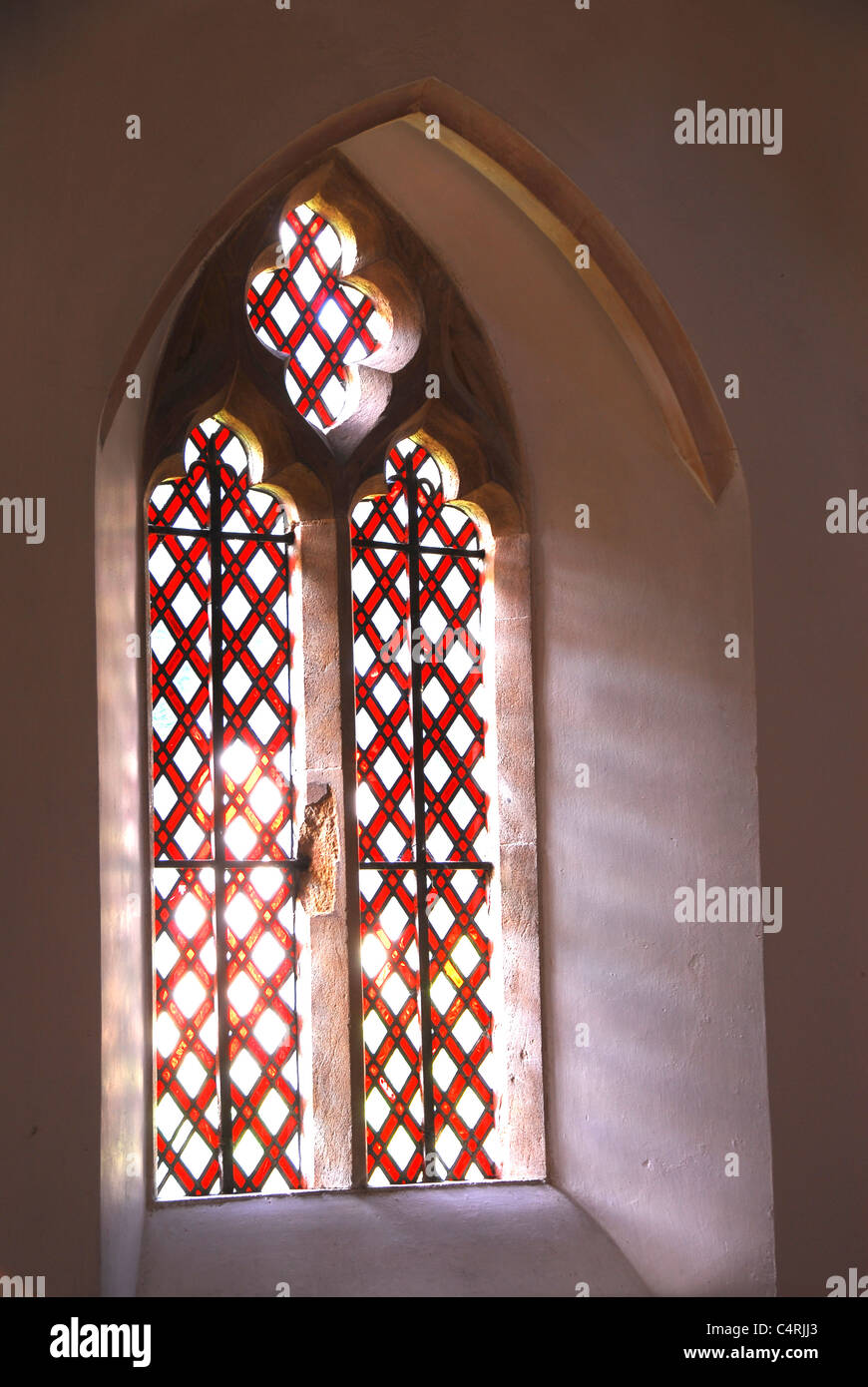 A stained glass window in a church, with the light shining through UK ...