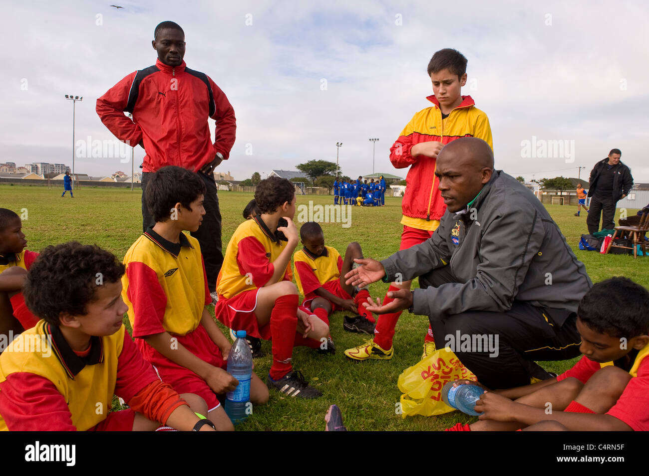 Football coach instructing the Rygersdal Under 13 team during half time ...