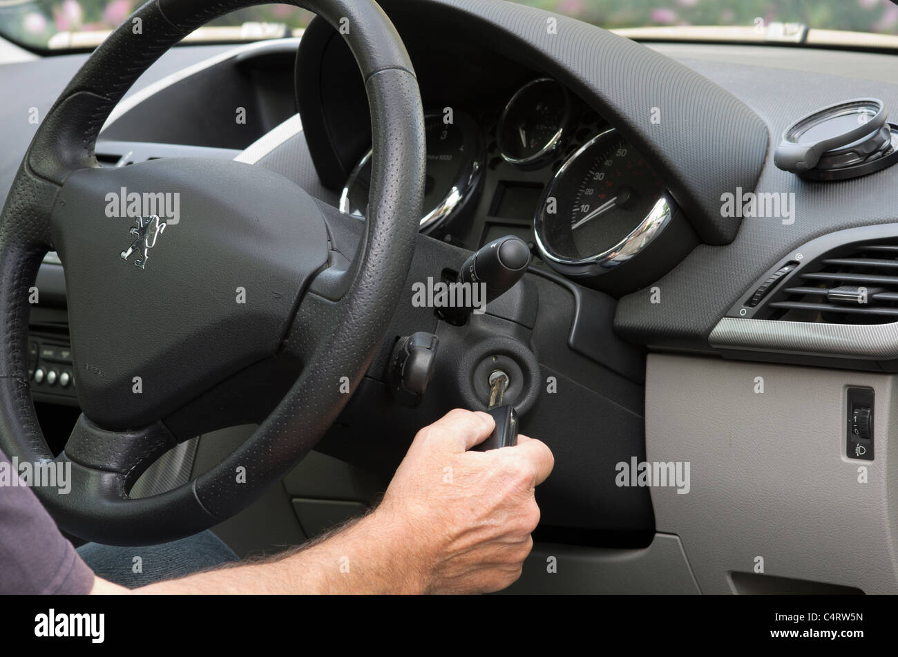 a hand on the ignition key of a car Stock Photo - Alamy