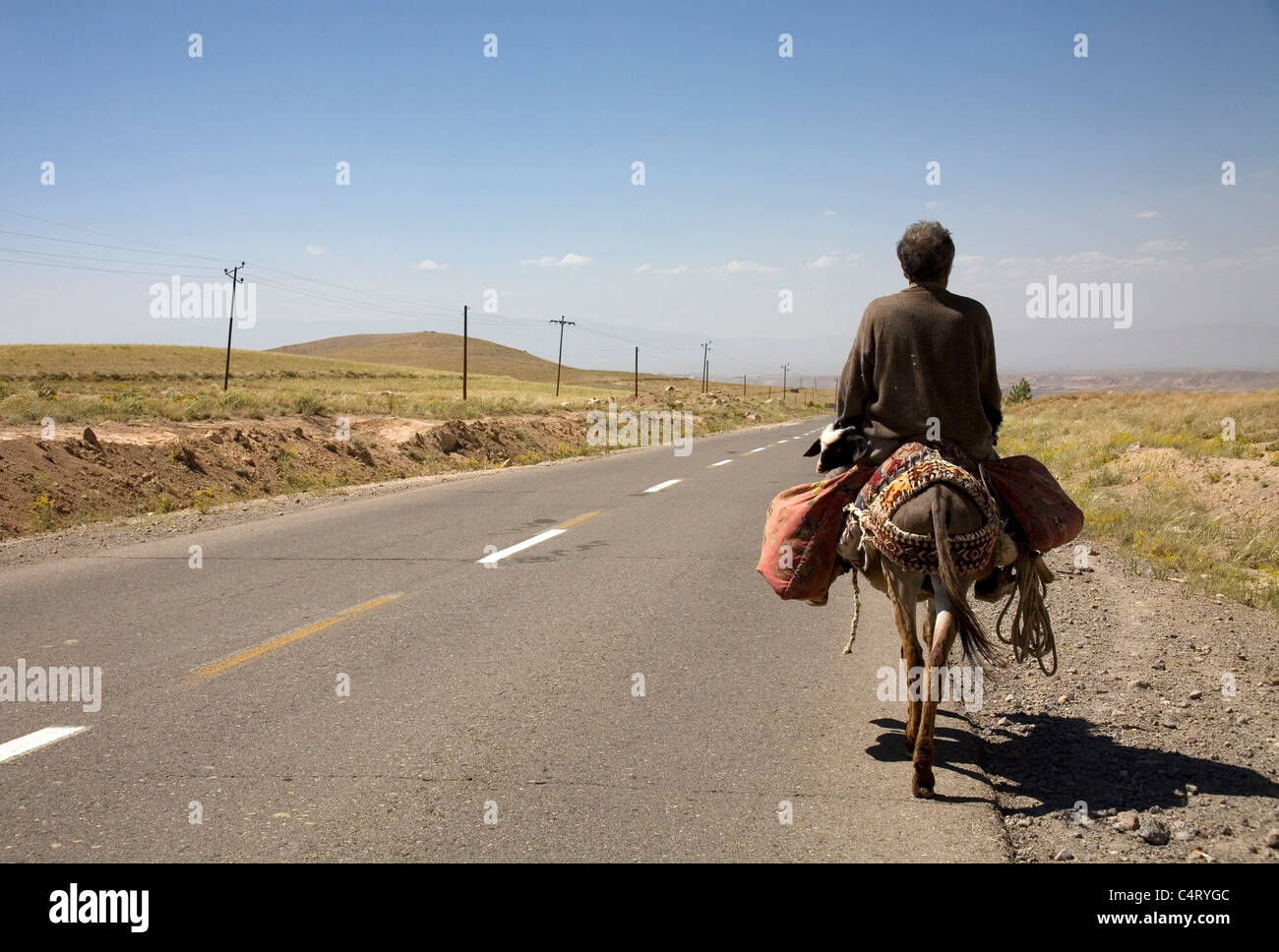 Lonely man riding donkey on the road between Kandovan and Osku, Iran ...