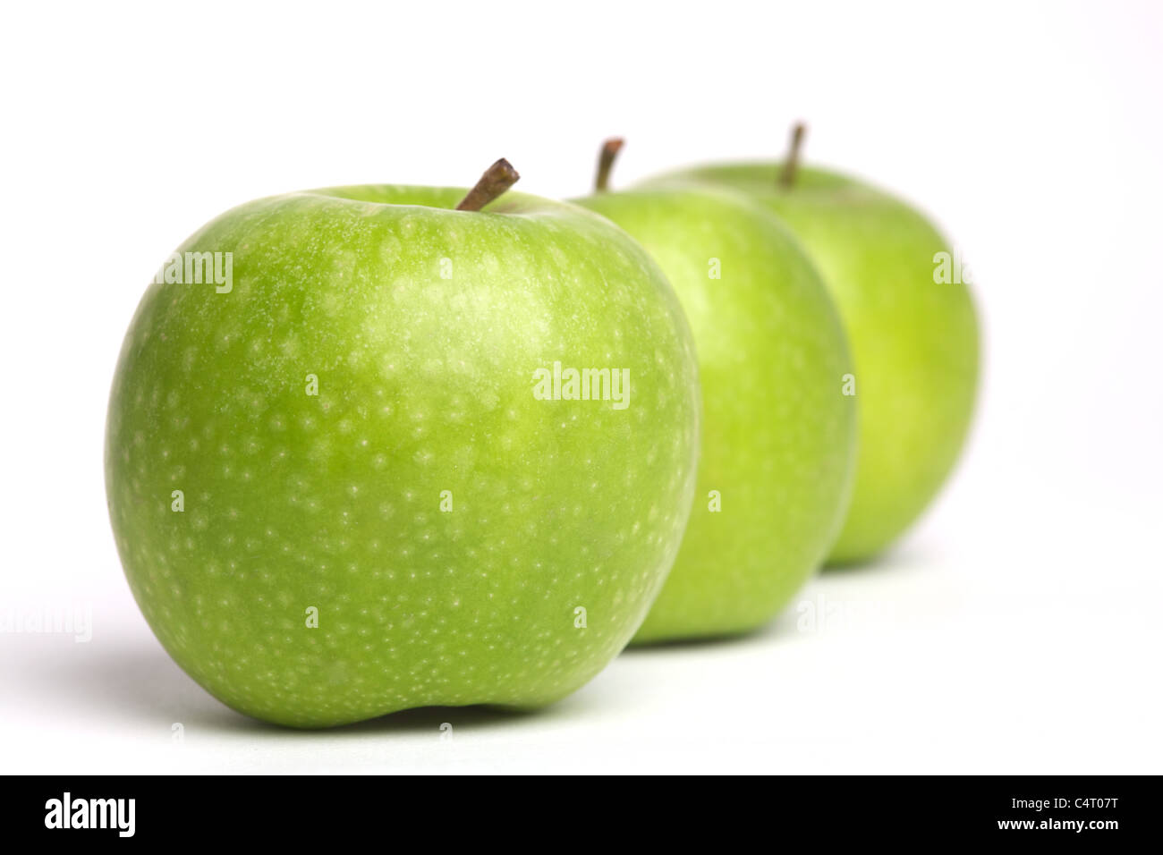 3 crunchy green apples in a row on a white background Stock Photo - Alamy