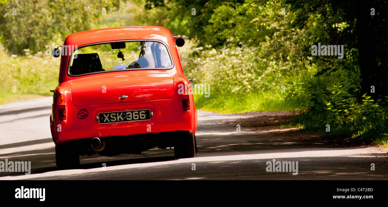 Renovated classic car 1959 Ford Anglia 100E driving in English country ...