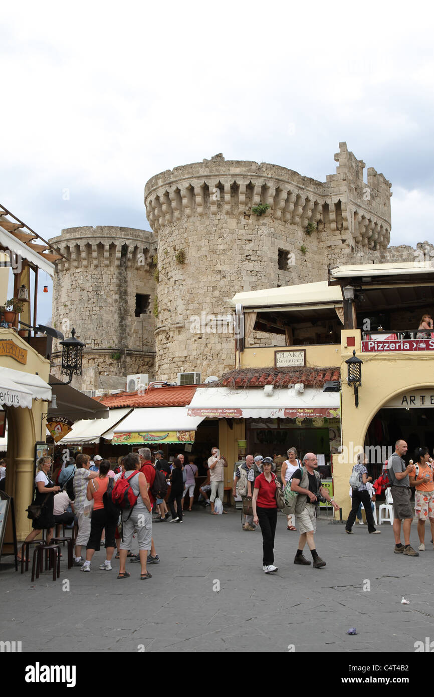 Bars and restaurants in the old town of Rhodes, Greece with the castle ...