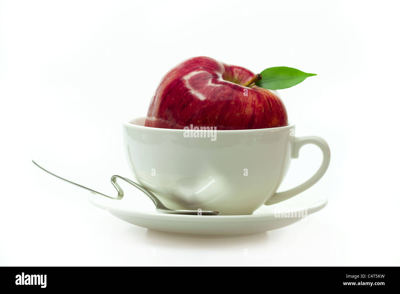 apple in a cup and spoon isolated on white Stock Photo - Alamy