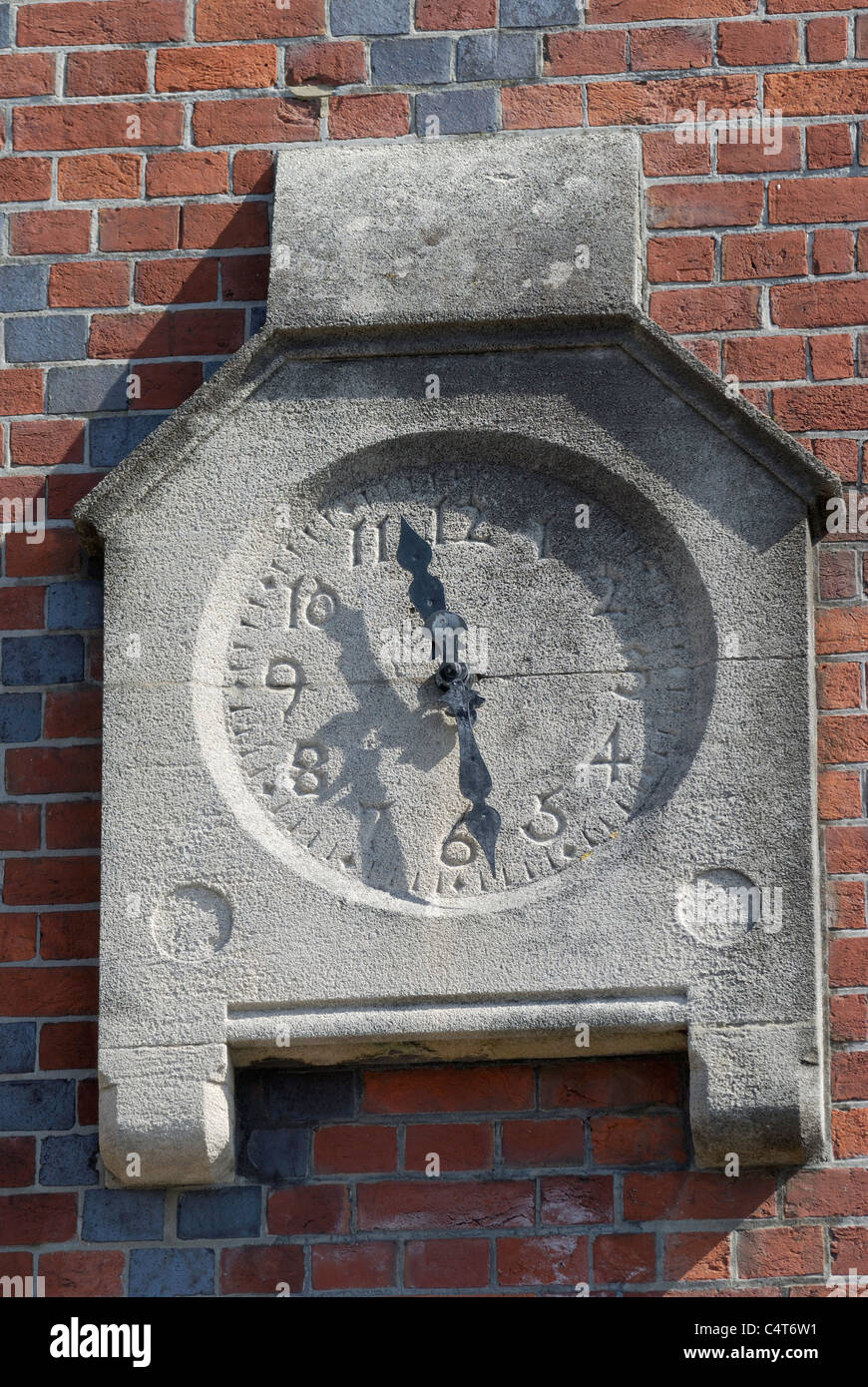 Stone clock on brick wall of building in High Street. Arundel. West ...