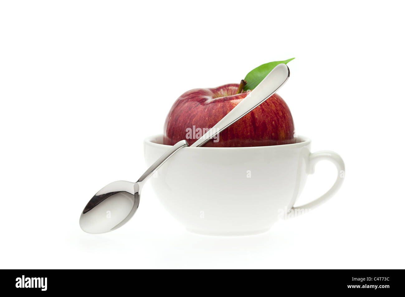apple in a cup and spoon isolated on white Stock Photo - Alamy