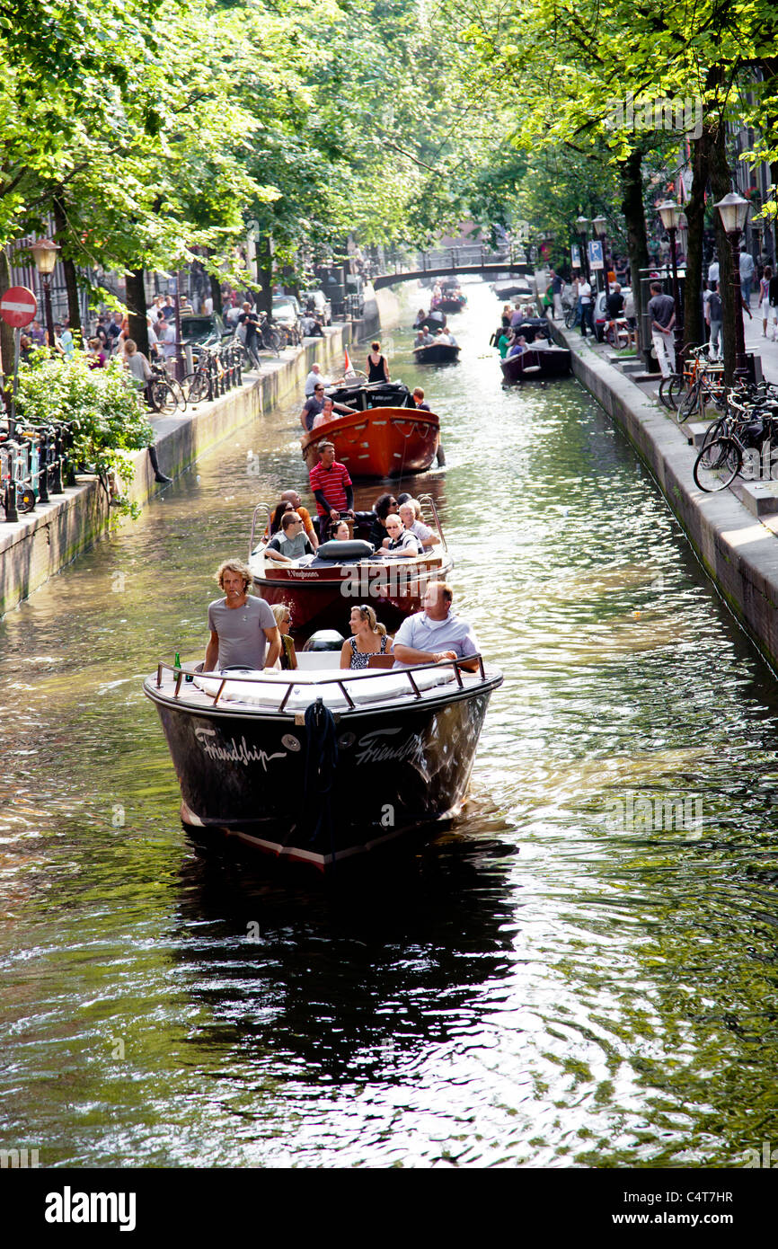 Boats floating down the river in Amsterdam downtown during summer party ...