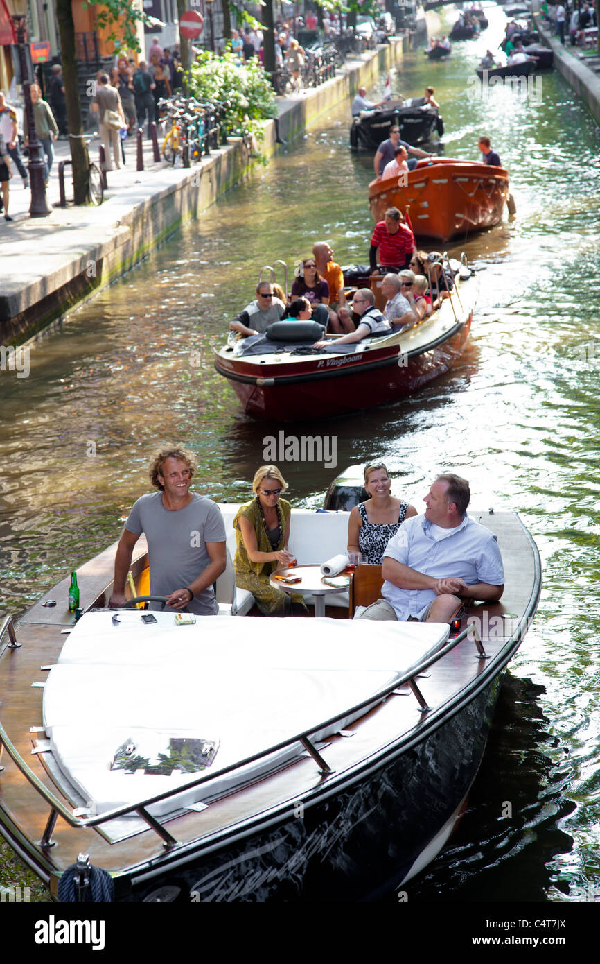 Boats floating down the river in Amsterdam downtown during summer party ...