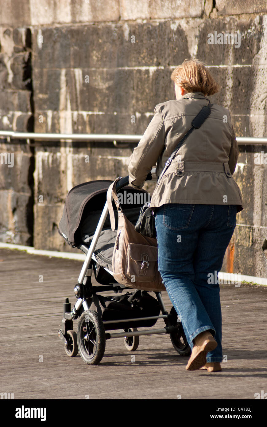 Woman pushing a buggy Stock Photo - Alamy