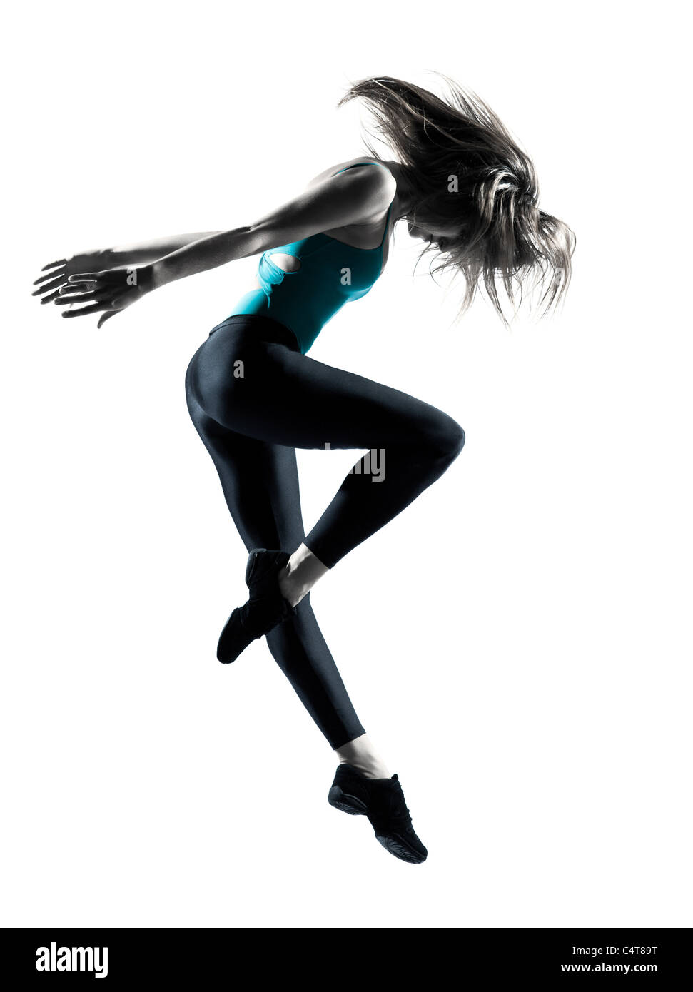 Side view of a flexible young female dancer jumping on white background ...