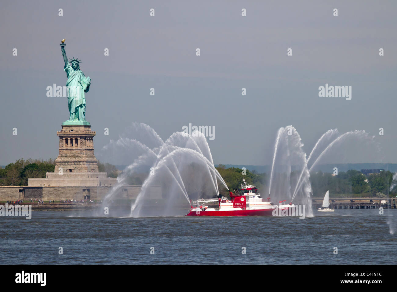 NYFD Fireboat 343 salutes the fleet as it passes the Statue of ...