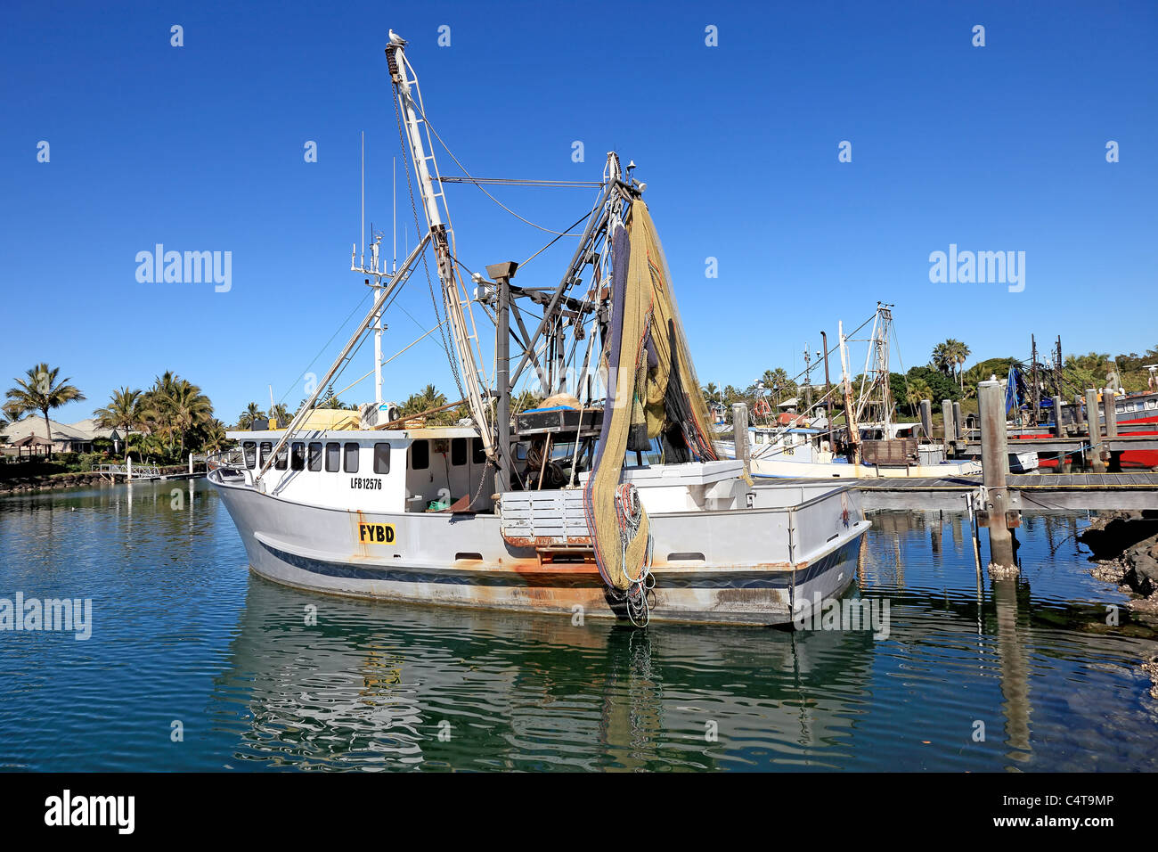 Fishing boats at rest in river estuary moored at a pier Stock Photo - Alamy