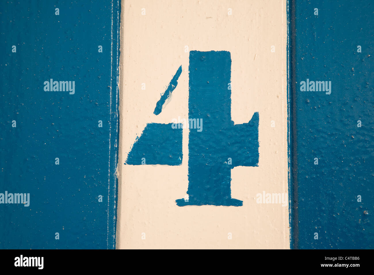 Four painted onto blue door Stock Photo - Alamy