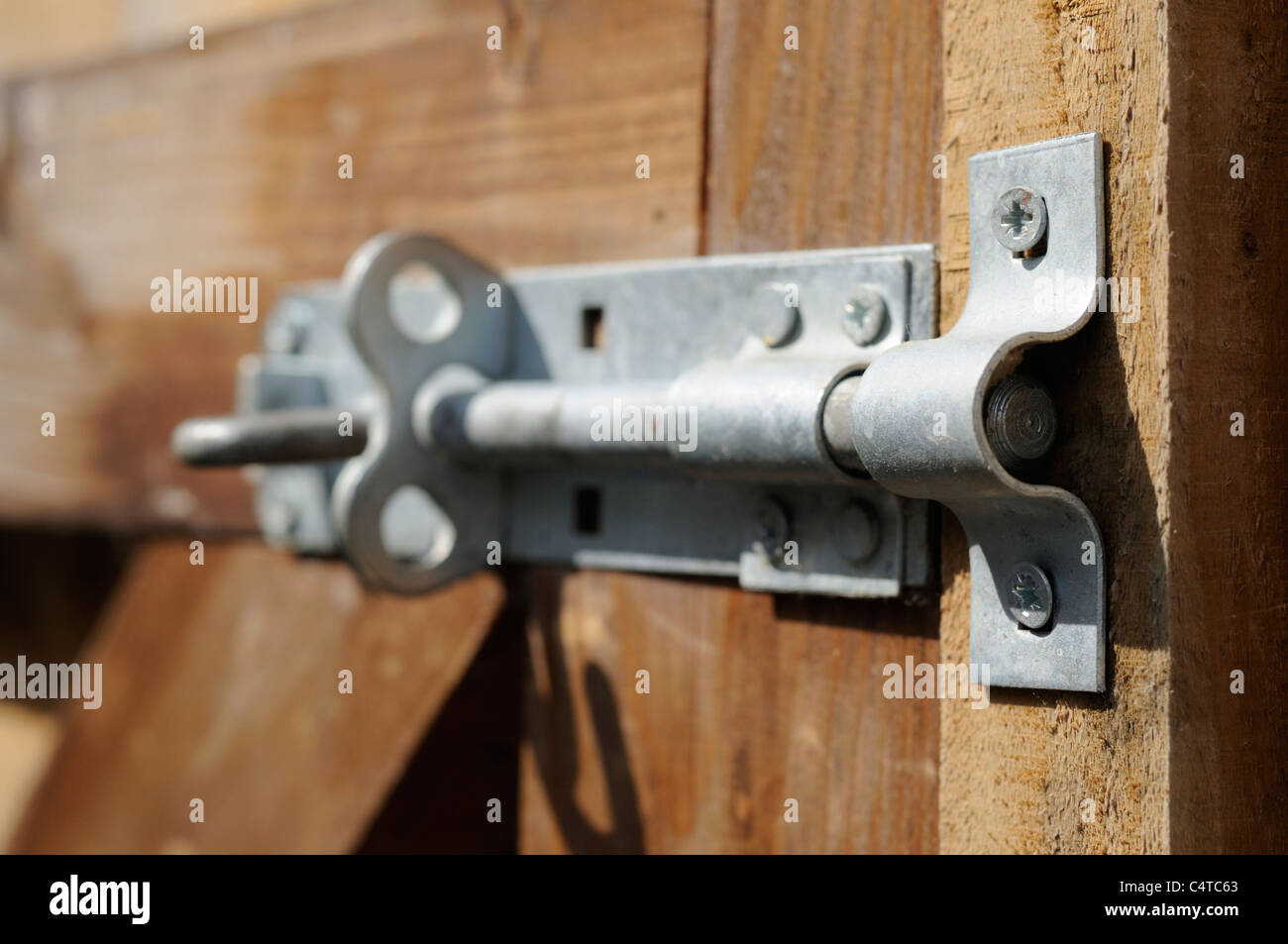 A close-up photo of a bolted metal latch on a wooden garden gate Stock ...