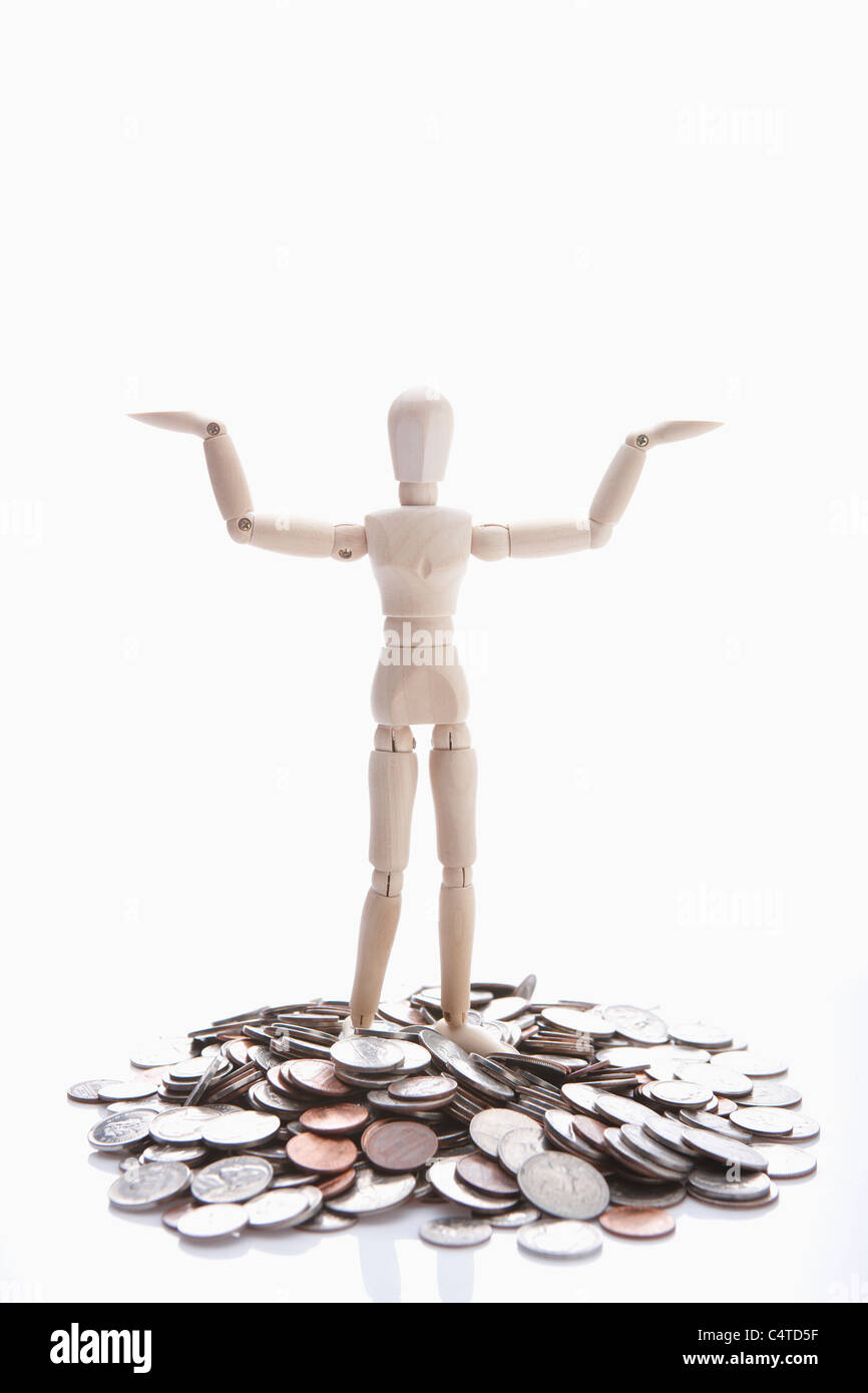 wooden doll stood in coins Stock Photo - Alamy