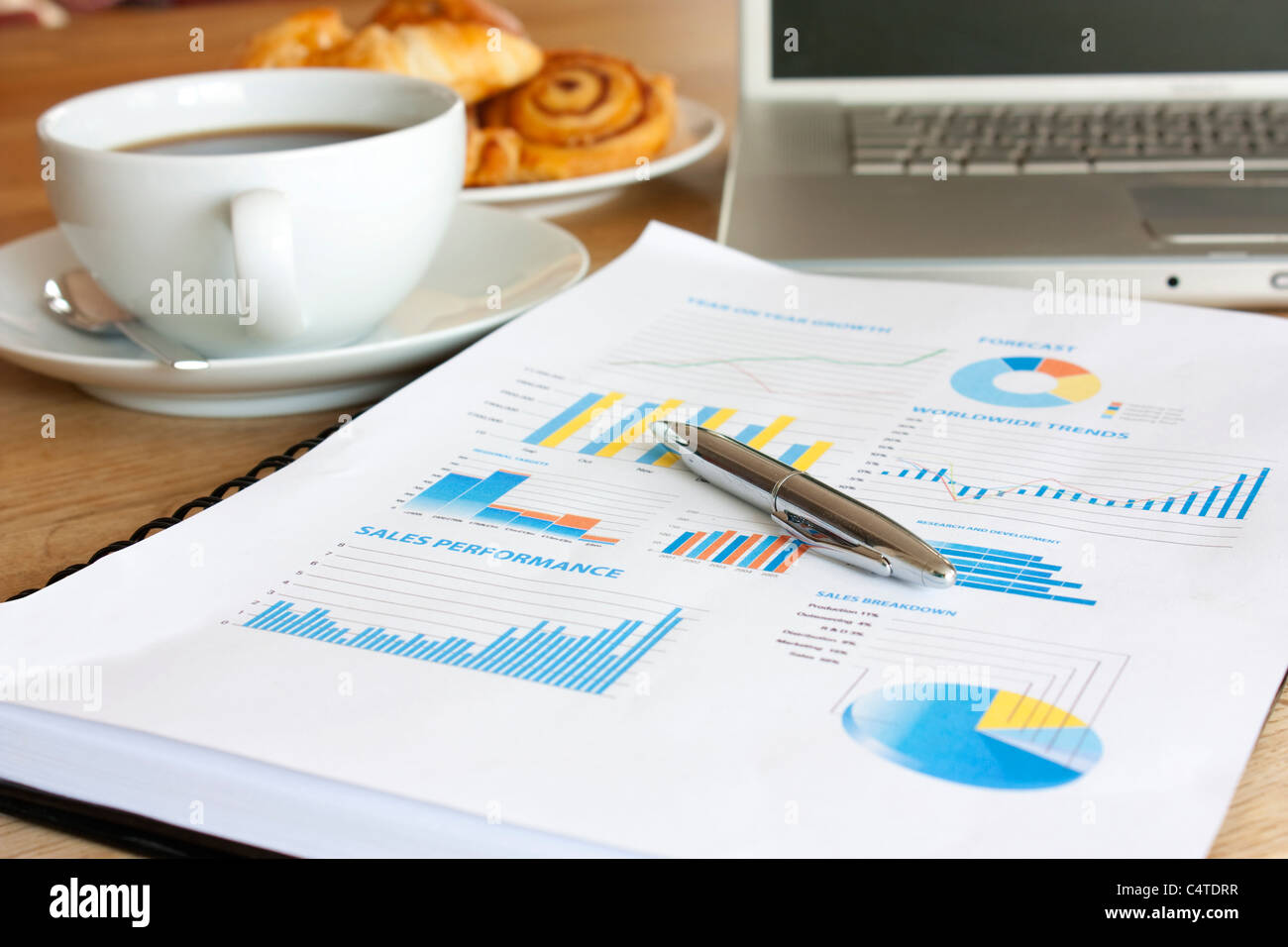 Business breakfast scene with graph, croissant, coffee and laptop Stock ...