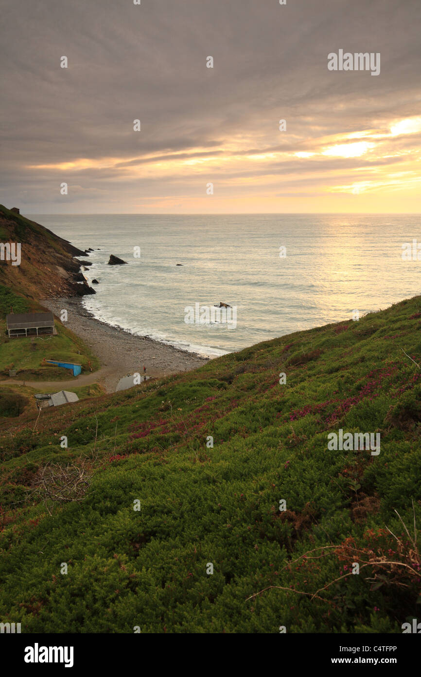 Setting sun at Millook Haven, viewed from coastal path, North Cornwall ...