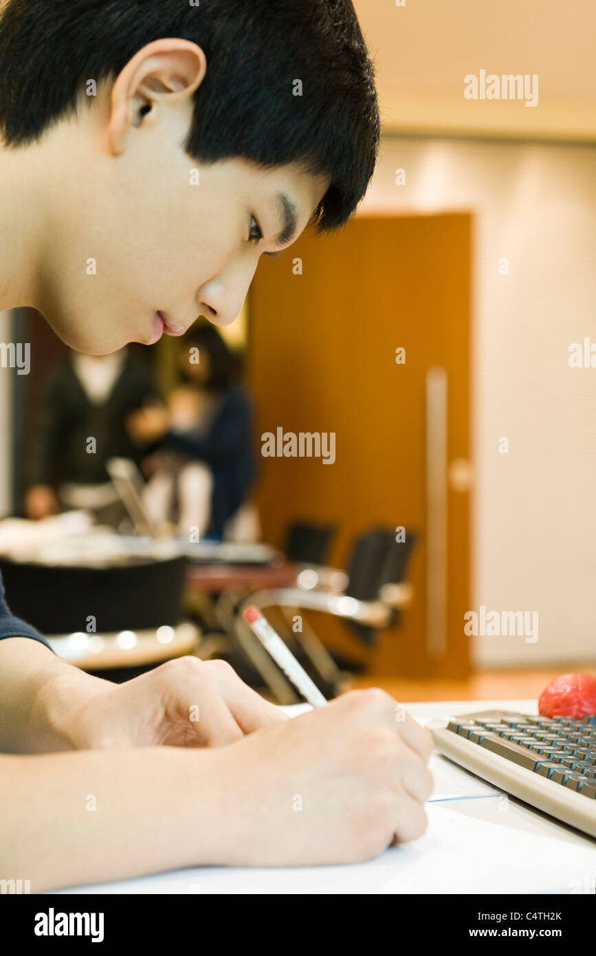 Young man writing at desk Stock Photo - Alamy