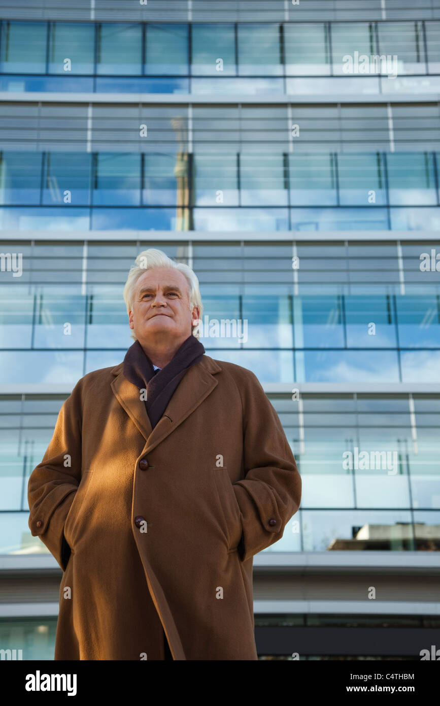 Executive standing in front of office building, portrait Stock Photo ...
