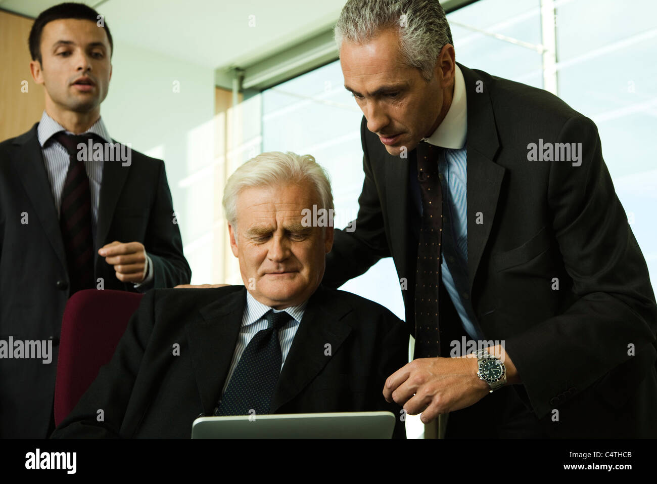 Executives looking down at digital tablet Stock Photo - Alamy