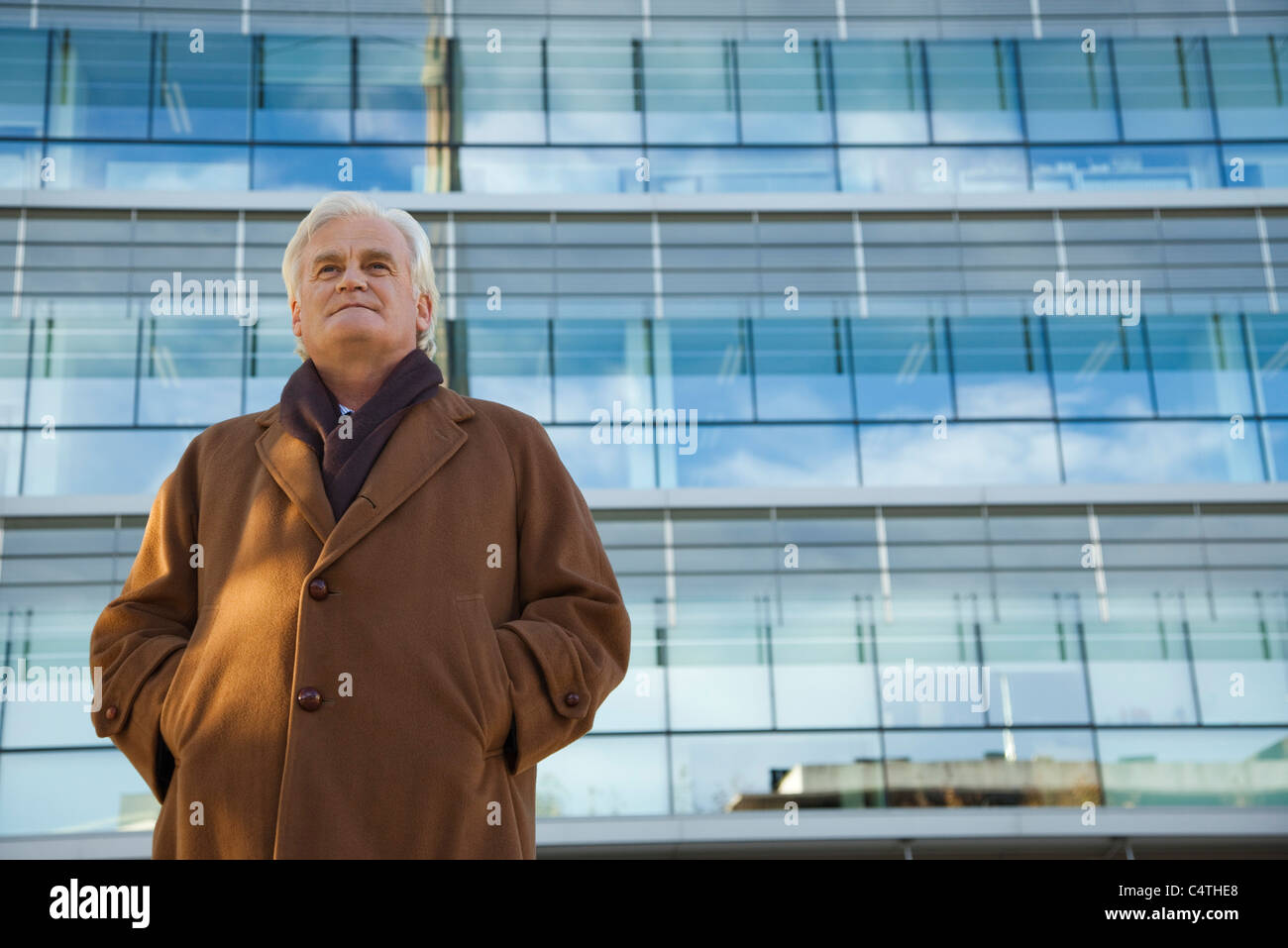 Mature man standing in front of building, looking away, portrait Stock ...