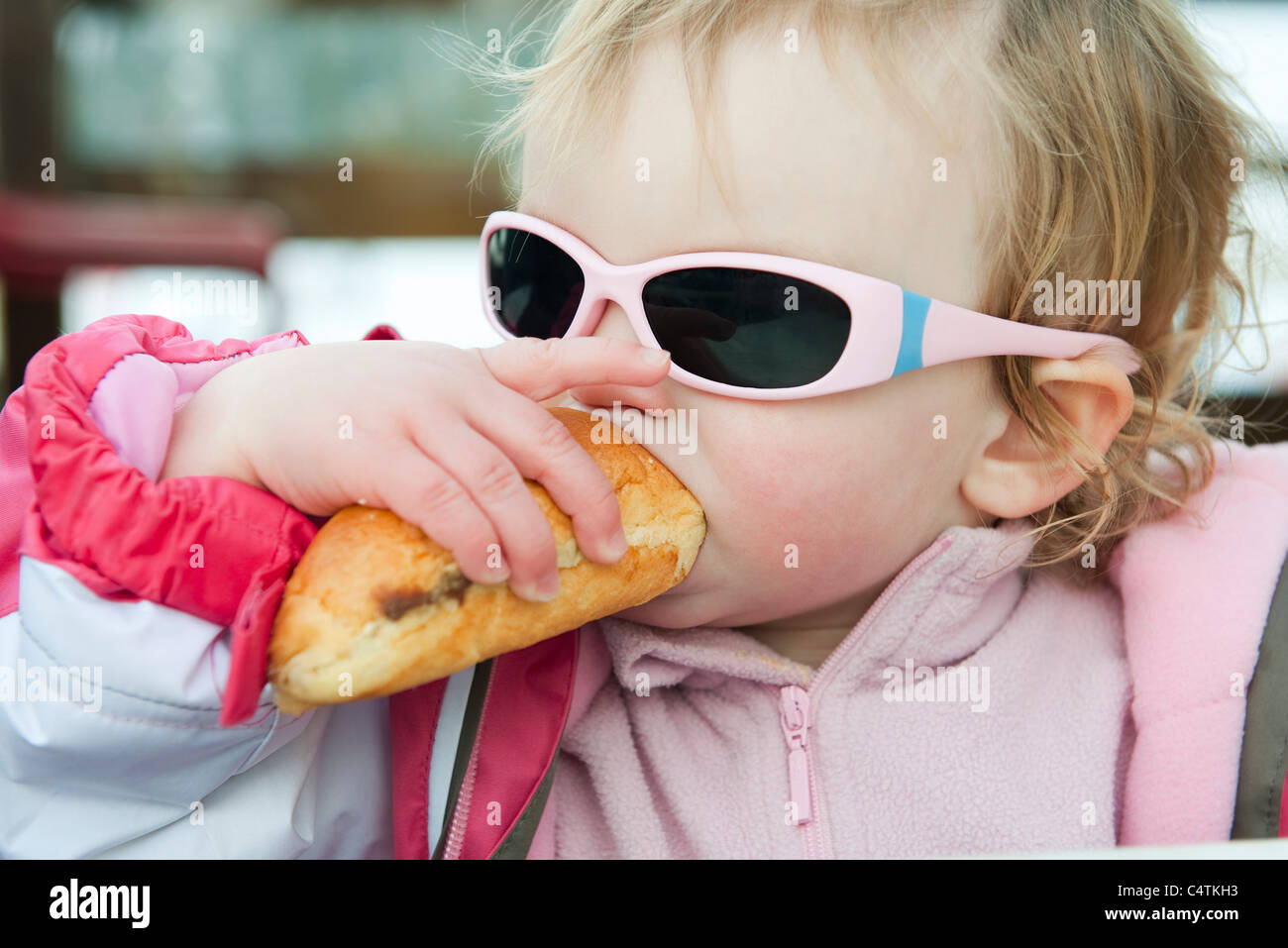 Toddler girl eating baguette Stock Photo - Alamy