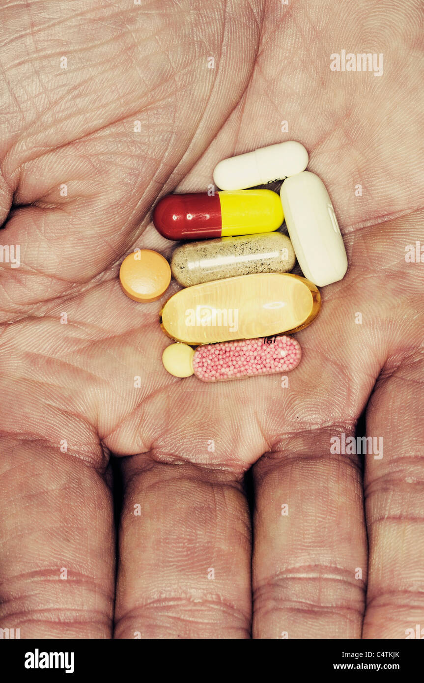 Assorted pills in man's hand Stock Photo - Alamy