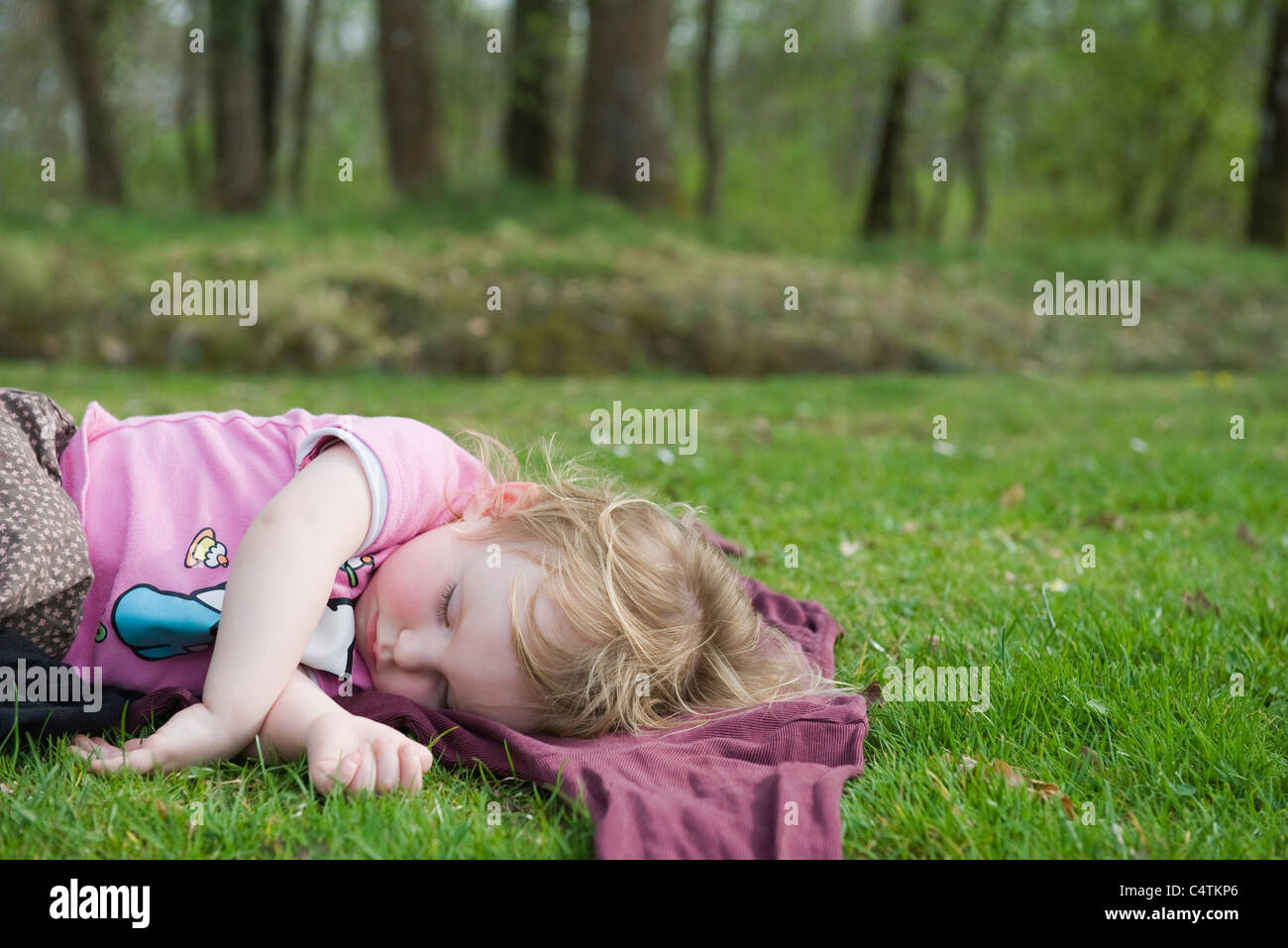 Toddler girl taking a nap outdoors Stock Photo - Alamy